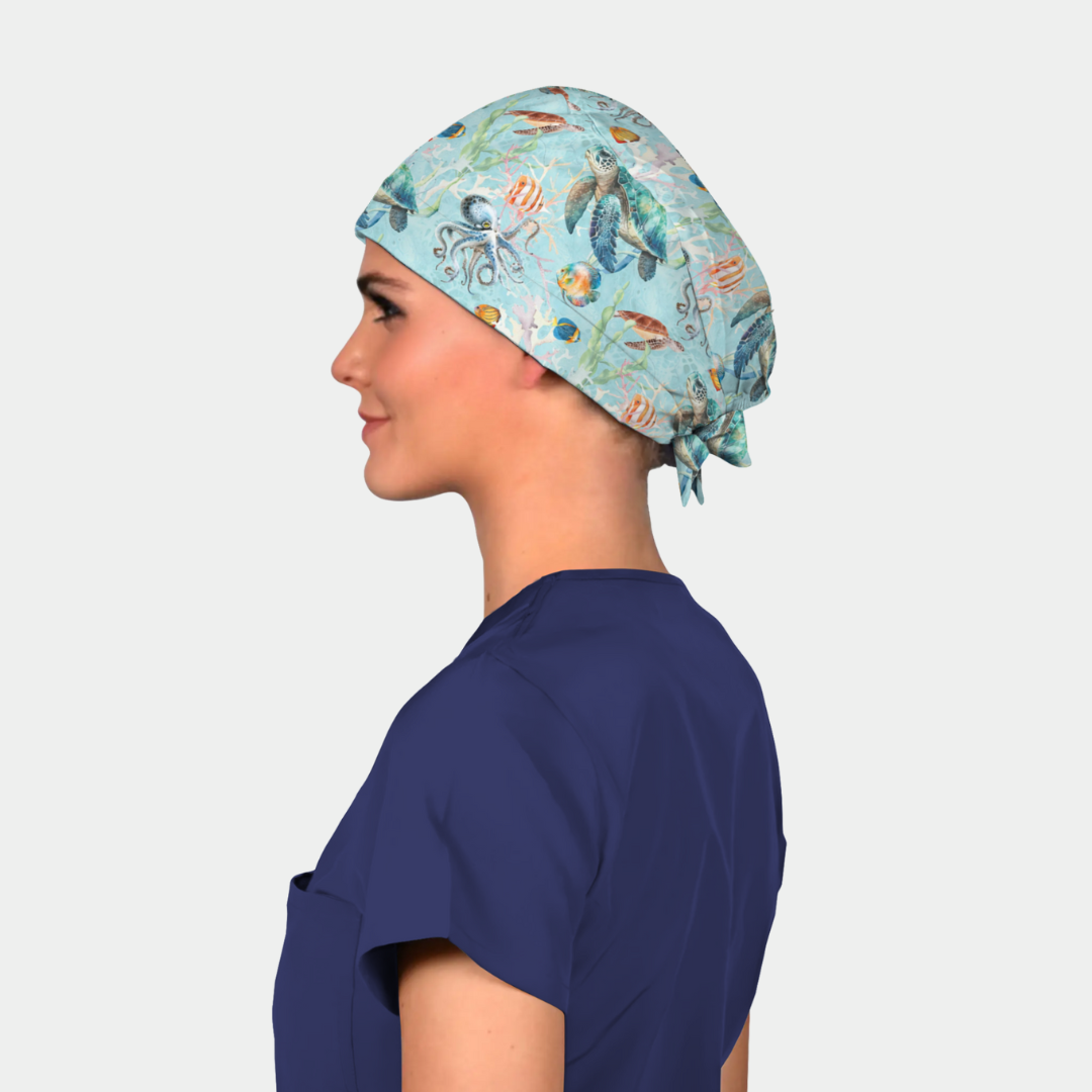 Person wearing a blue scrub cap with a sea-themed design on a plain ...