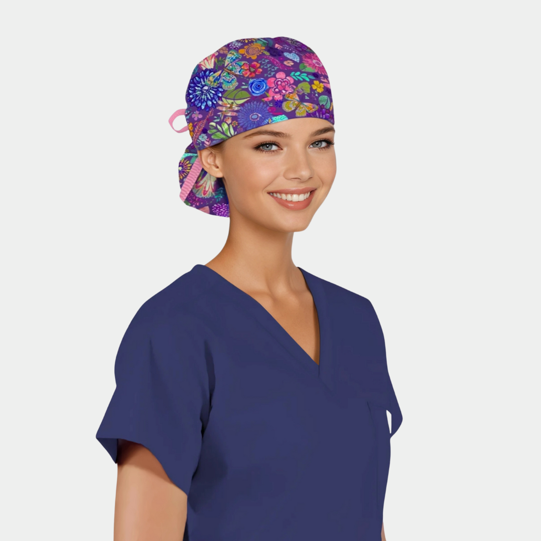 Woman wearing a colorful floral scrub cap and blue scrub top on a white ...