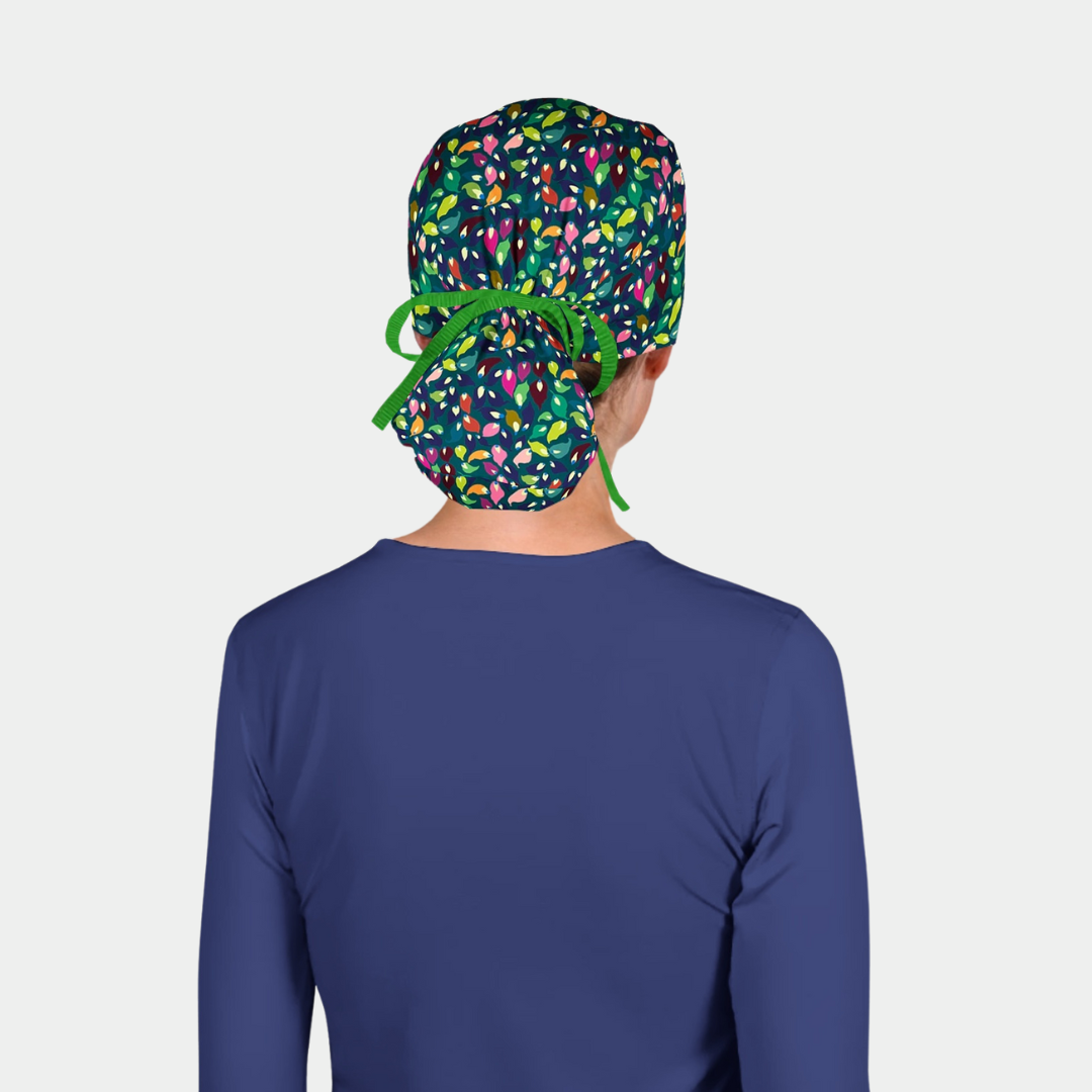 Person wearing a colorful patterned scrub cap on a plain background