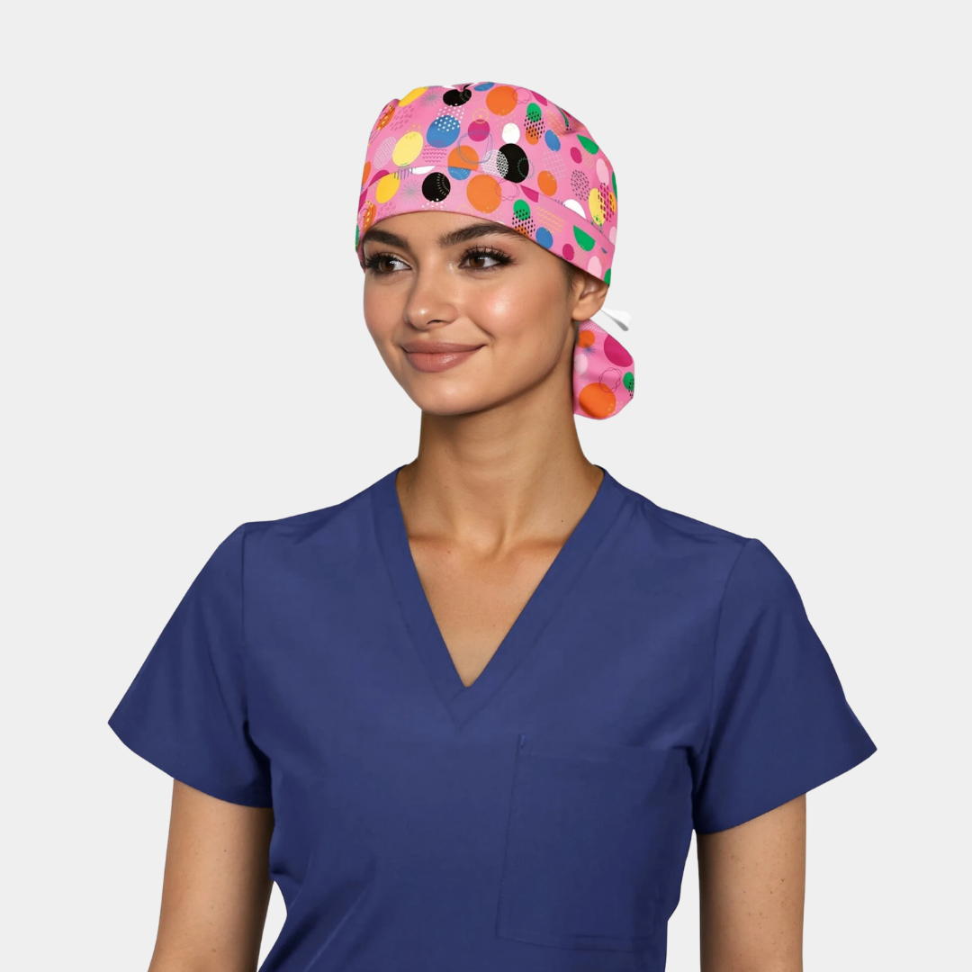 Woman wearing a colorful polka dot scrub cap and blue scrub top on a ...