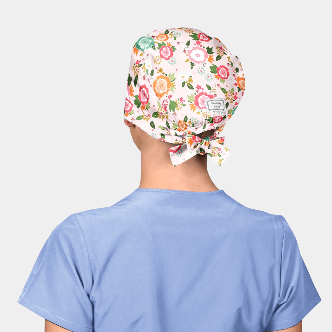 Person wearing a pink floral scrub cap on a plain background and a ...